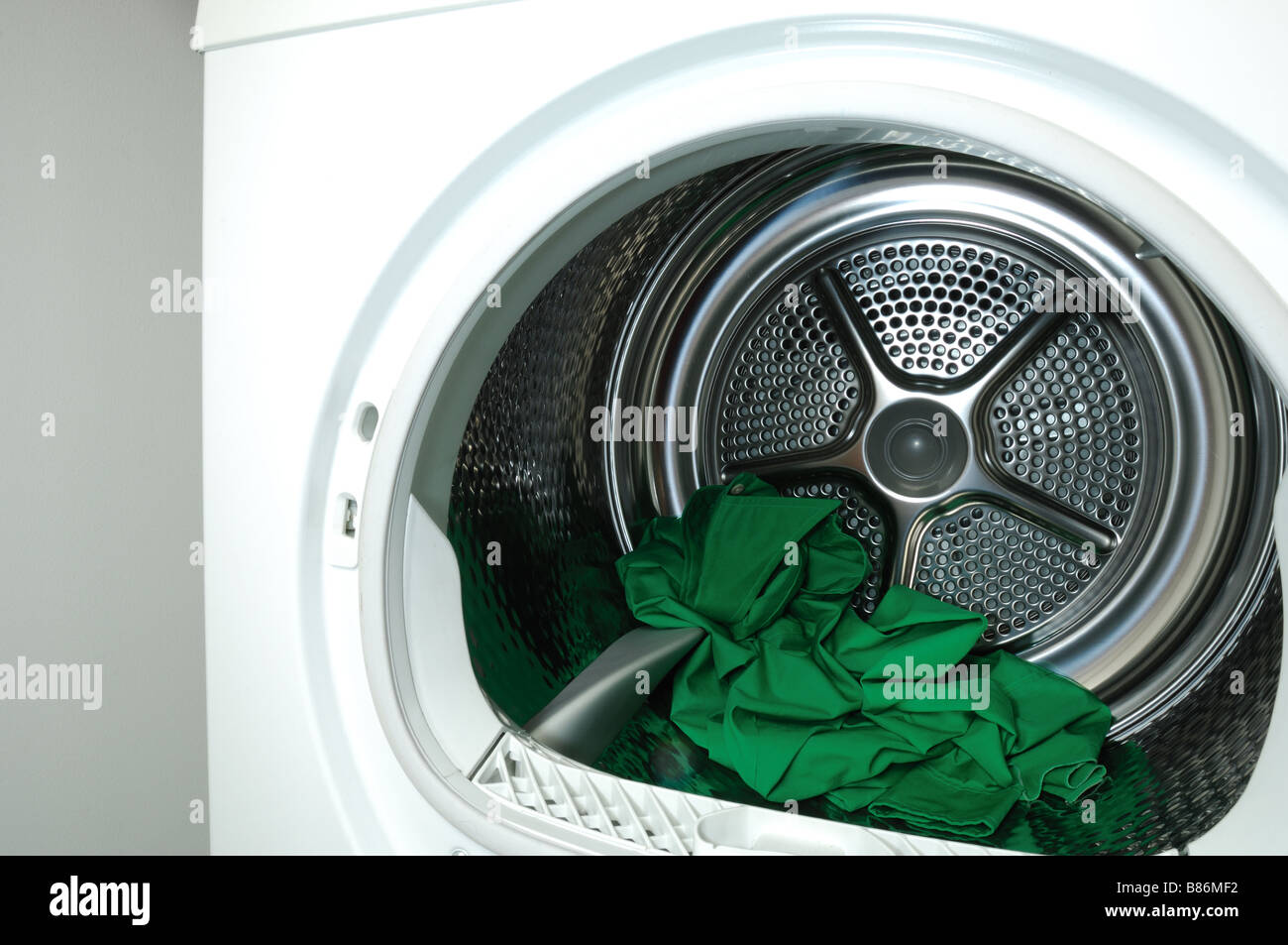 A green shirt inside a laundry washing machine drying machine Stock ...