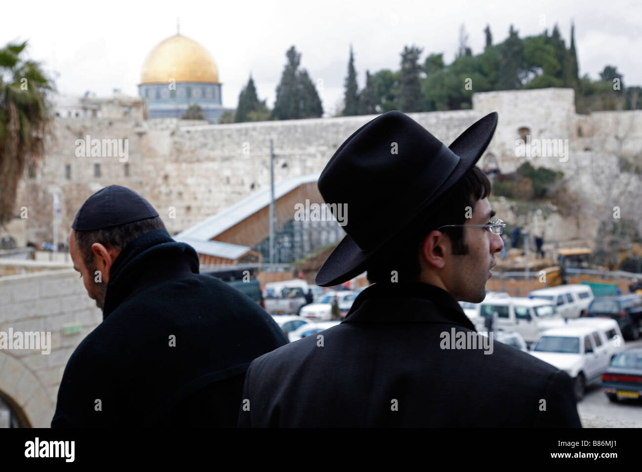 Two orthodox Israeli Jews standing in front of the Western Wall and the ...