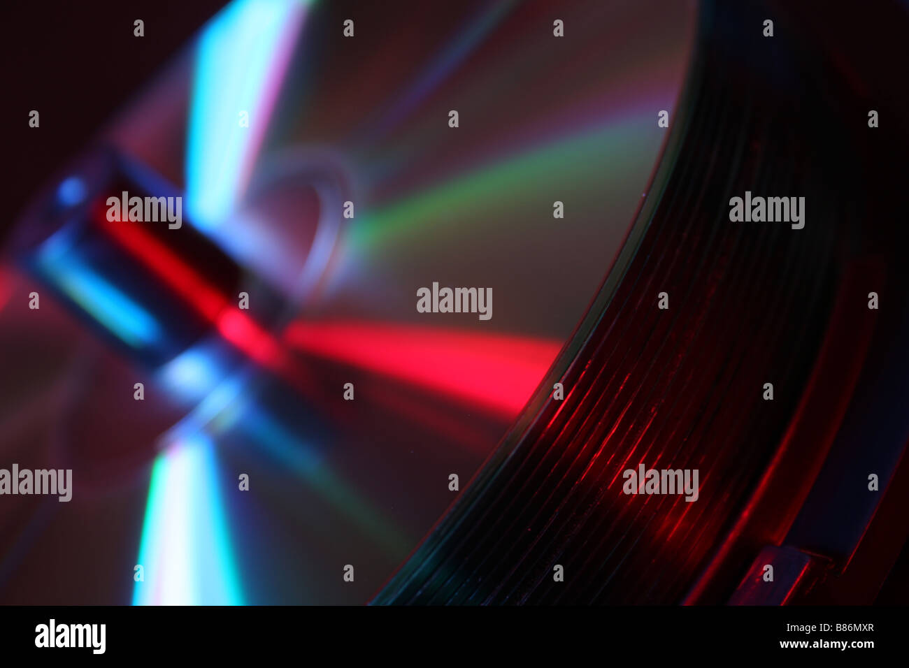 stack of CD's on a spindle lit with red and blue studio lighting Stock ...