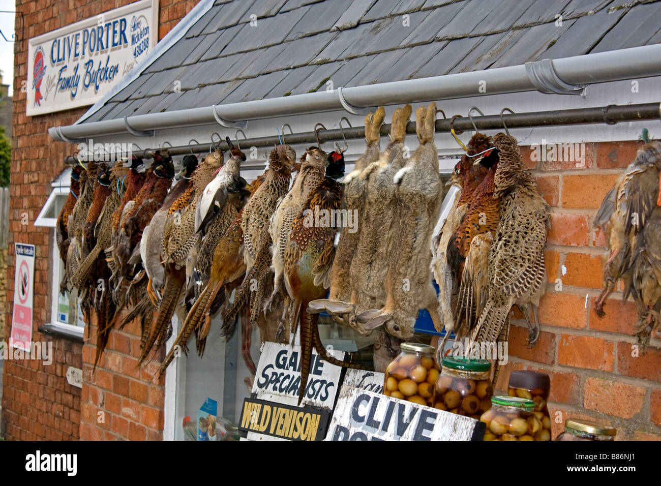 Game hanging outside the local butchers shop Stock Photo - Alamy