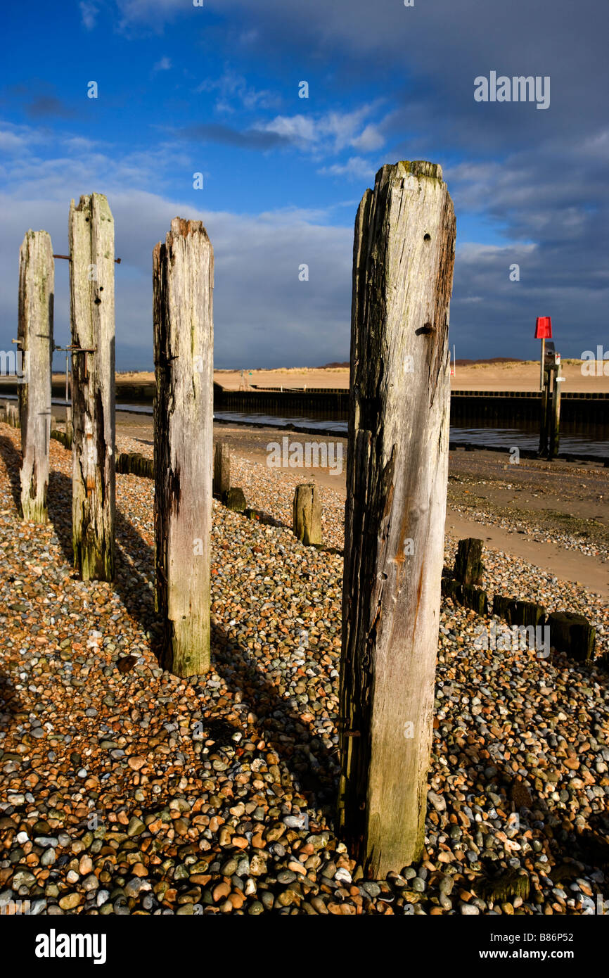 A row of wooden posts on the shingle banks of the River Rother, Rye ...