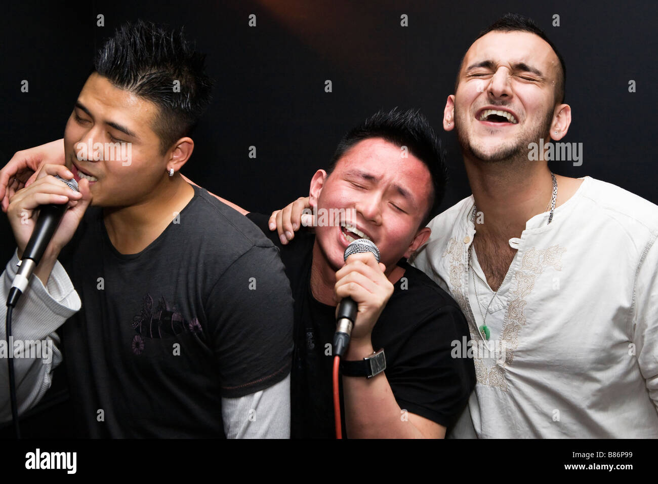 A group of friends singing karaoke in a bar Stock Photo - Alamy