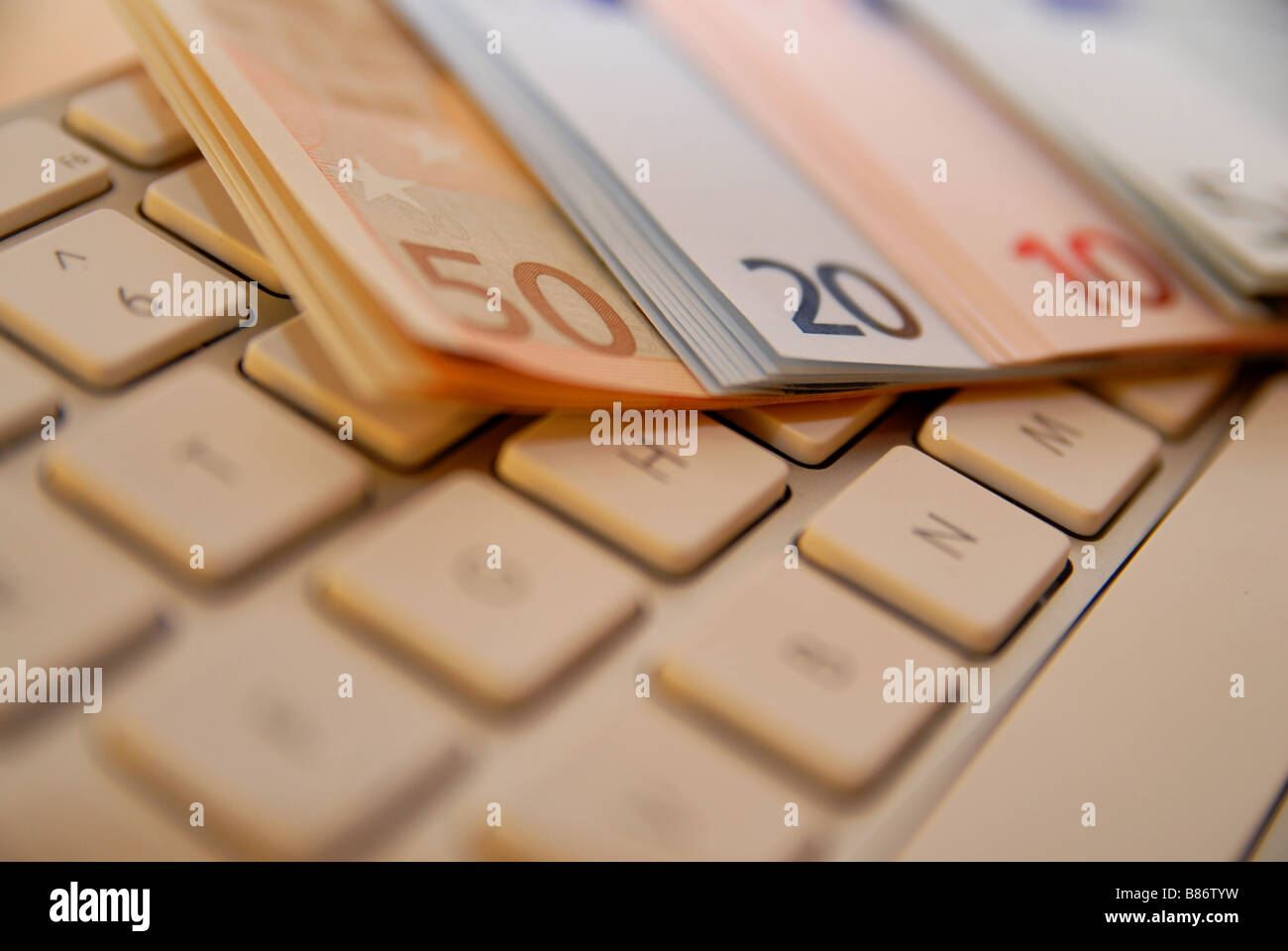 A stack / pile of new EURO bank notes ( currency money ) on a computer ...