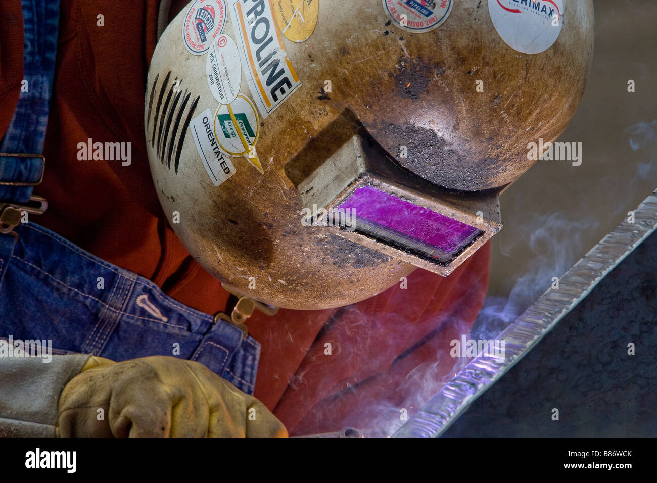 A welder wearing a welding mask welding Stock Photo - Alamy