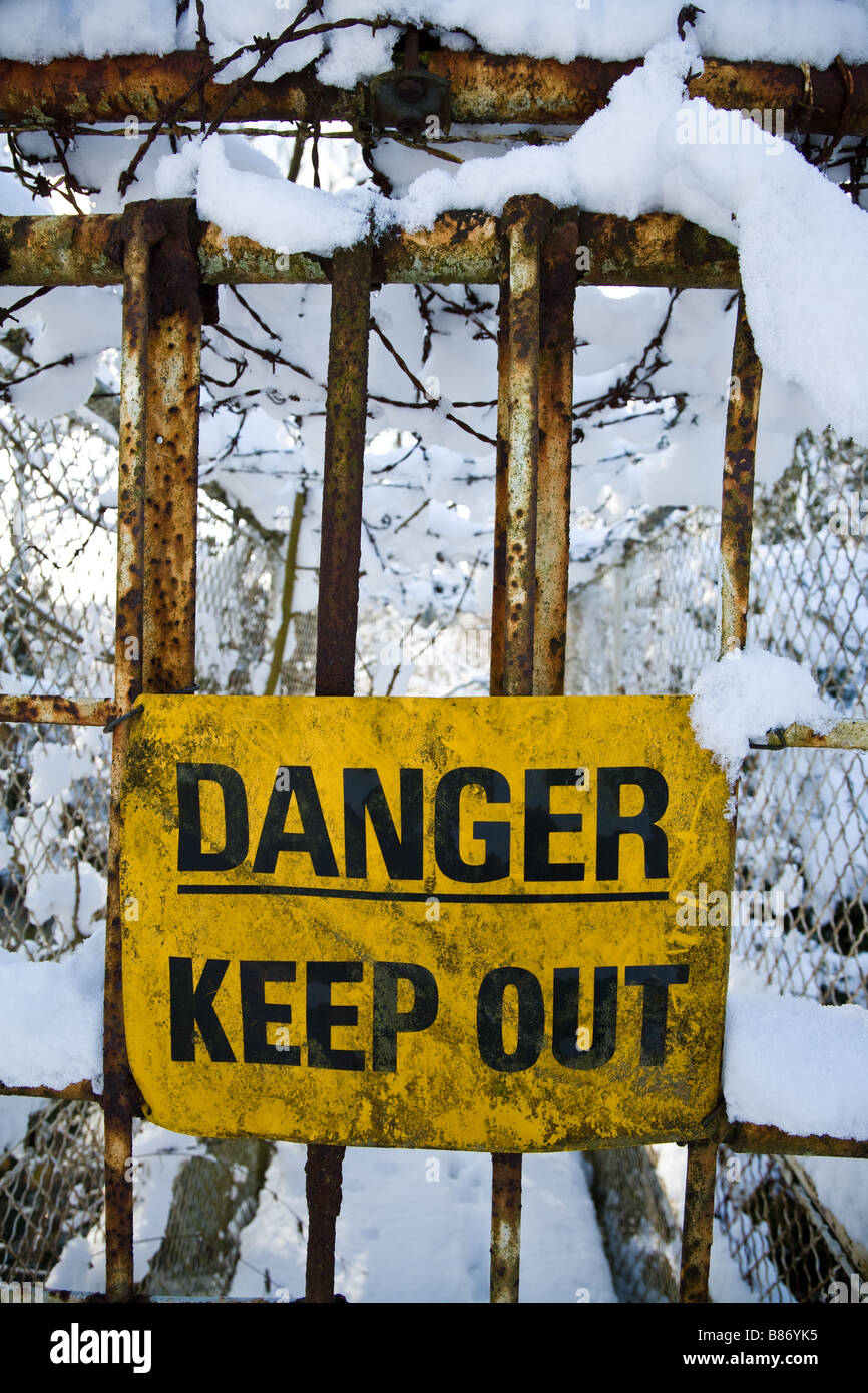 Danger Keep Out - a sign on a locked metal gate leading to an ...