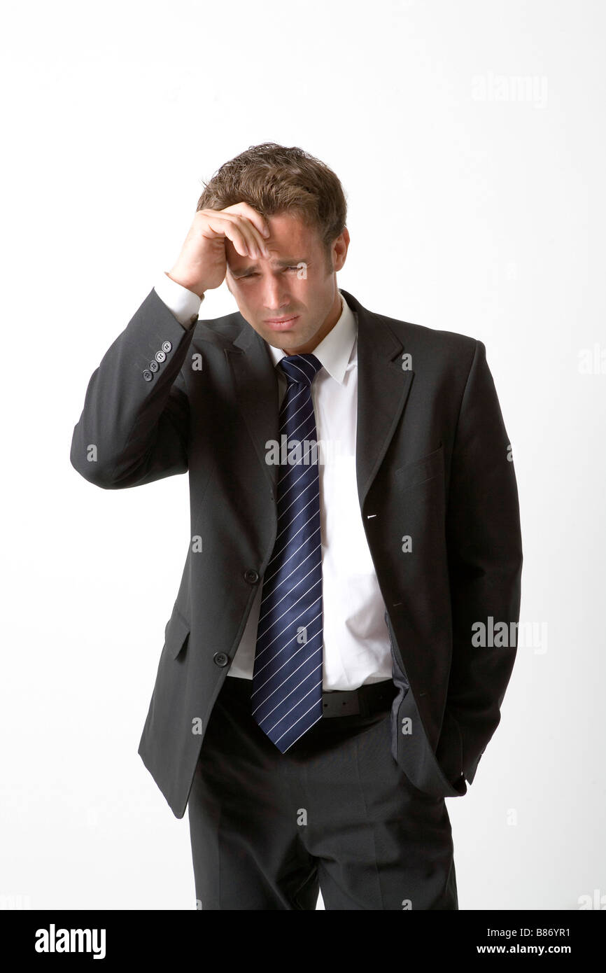 Businessman with hand on forehead standing looking down Stock Photo - Alamy