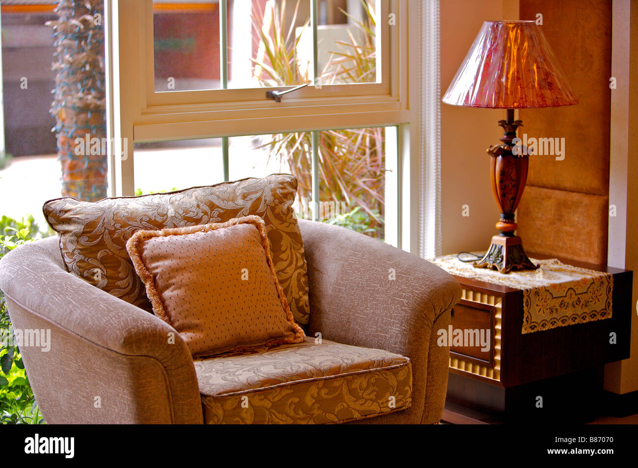 Single sofa with lamp on side table by window Stock Photo - Alamy