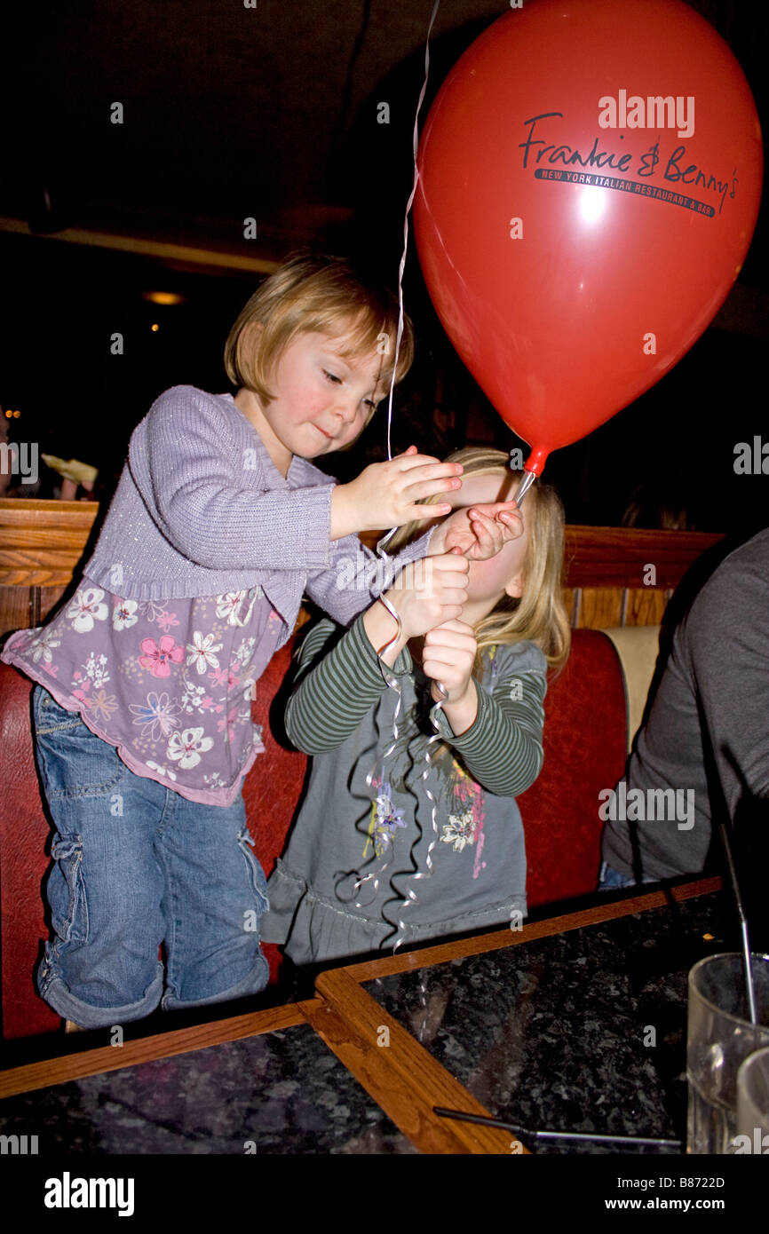 Young girls playing with balloon at a party Stock Photo - Alamy