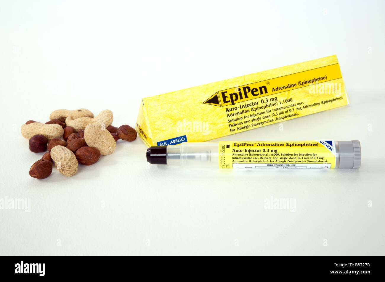Nut allergy - an epipen containing adrenaline and a selection of nuts ...