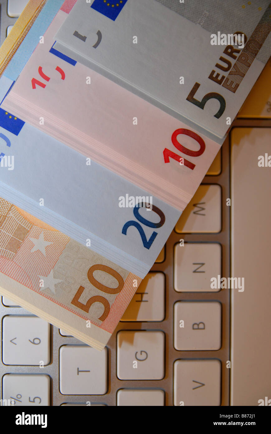 A stack / pile of new EURO bank notes ( currency money ) on a computer ...