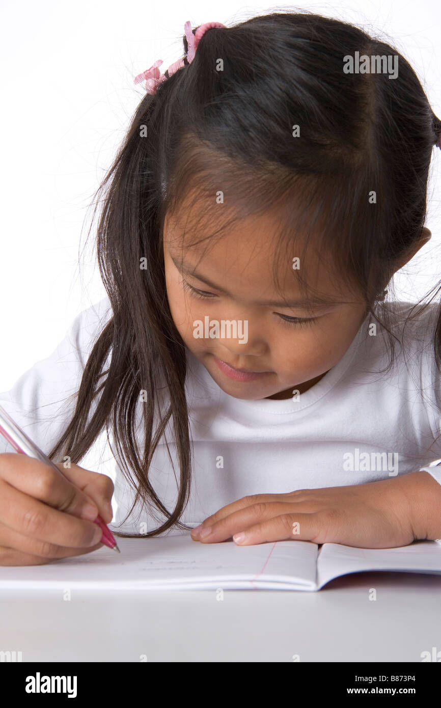 Little girl is writing in her excercise book Stock Photo - Alamy