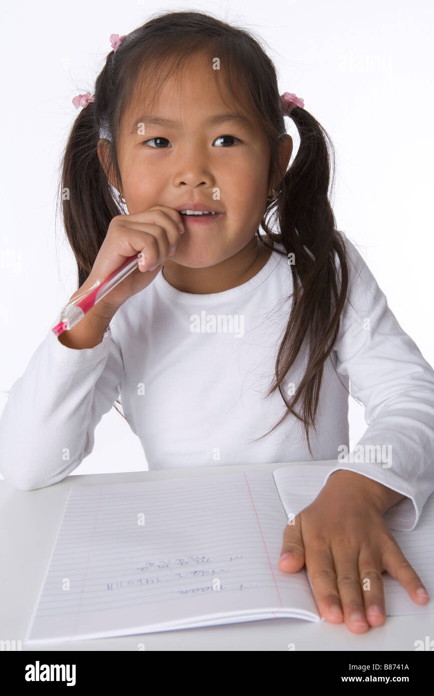 Little girl is thinking about her writing Stock Photo - Alamy
