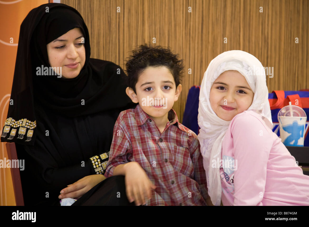 Muslim mother and children in the departure lounge of Bahrain ...
