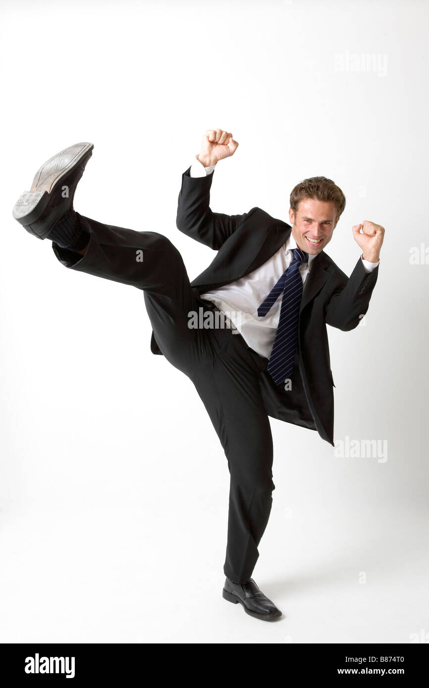 Businessman cheering with one leg up Stock Photo - Alamy