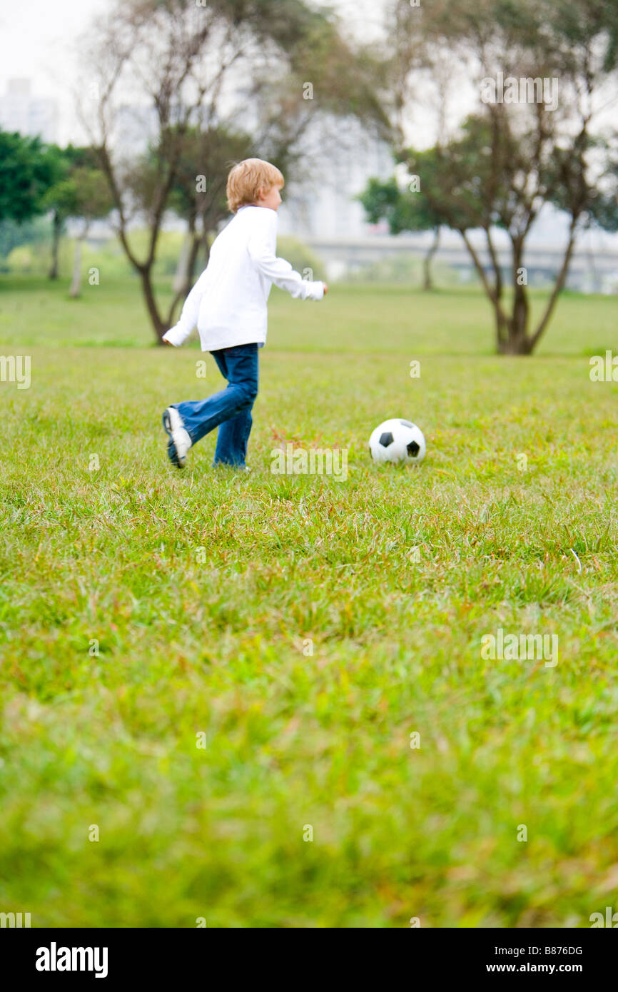 Boy playing soccer rear view Stock Photo - Alamy