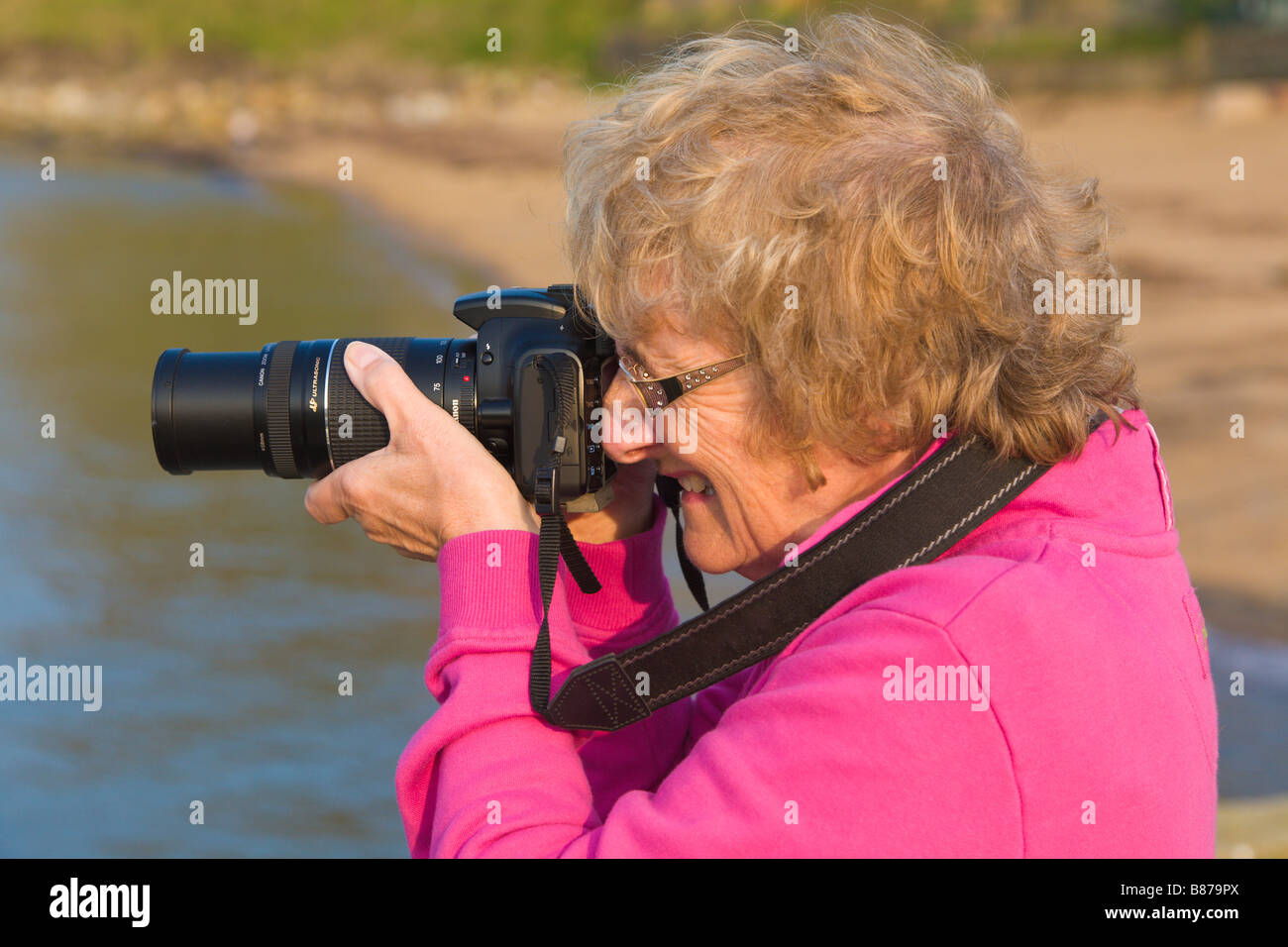Woman taking picture with Canon digital camera, England Stock Photo - Alamy