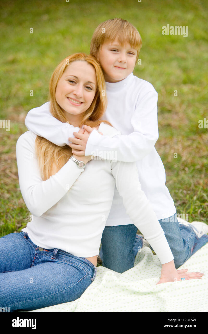 Boy putting his arms around mother s neck Stock Photo - Alamy