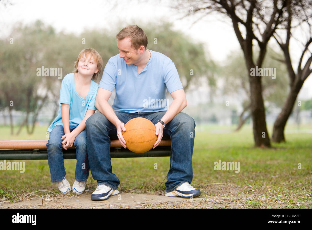 Father looking at his son with basketball in his hands Stock Photo - Alamy