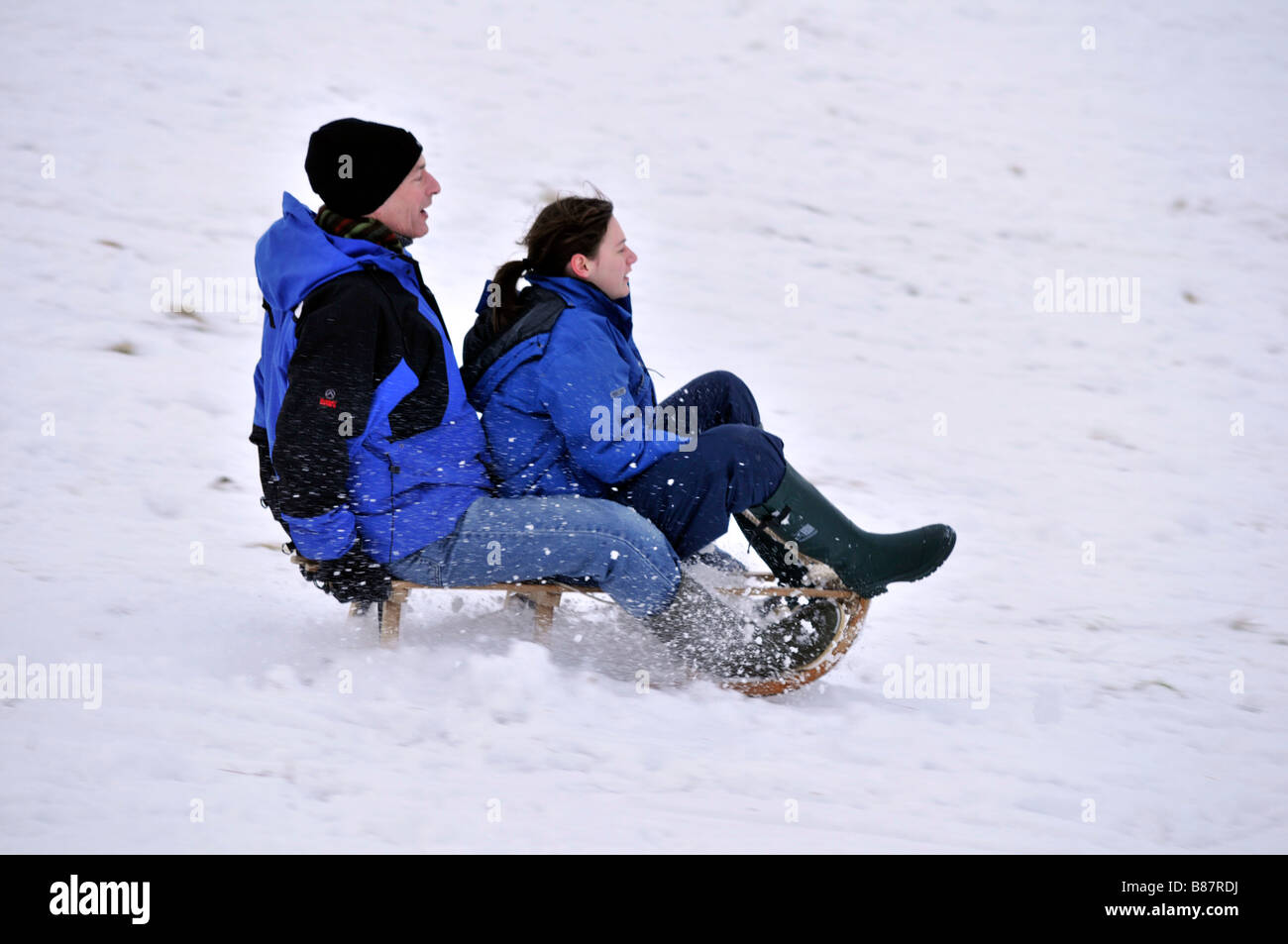Snow scene with couple sledging in Derbyshire after heavy snowfall in ...