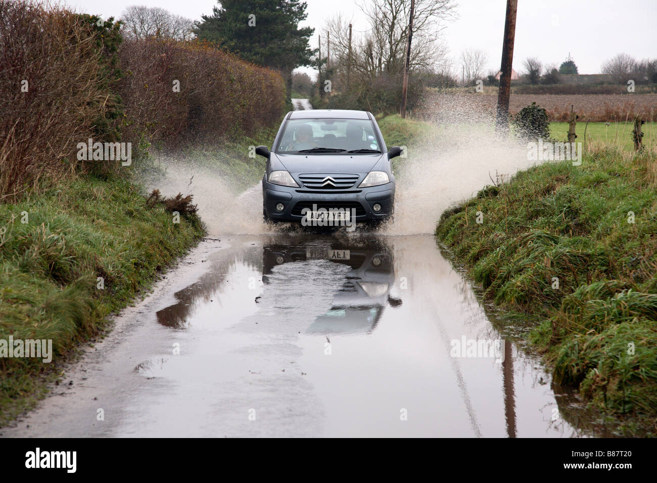 Car driving along flooded road Stock Photo - Alamy
