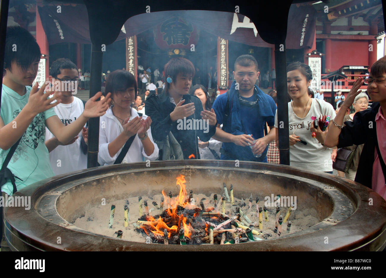 Group of young people taking in incense smoke at Senso-ji, Asakusa ...