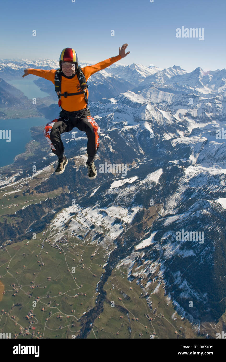 Skydiver is sit flying in the sky over the beautiful mountain scenery ...