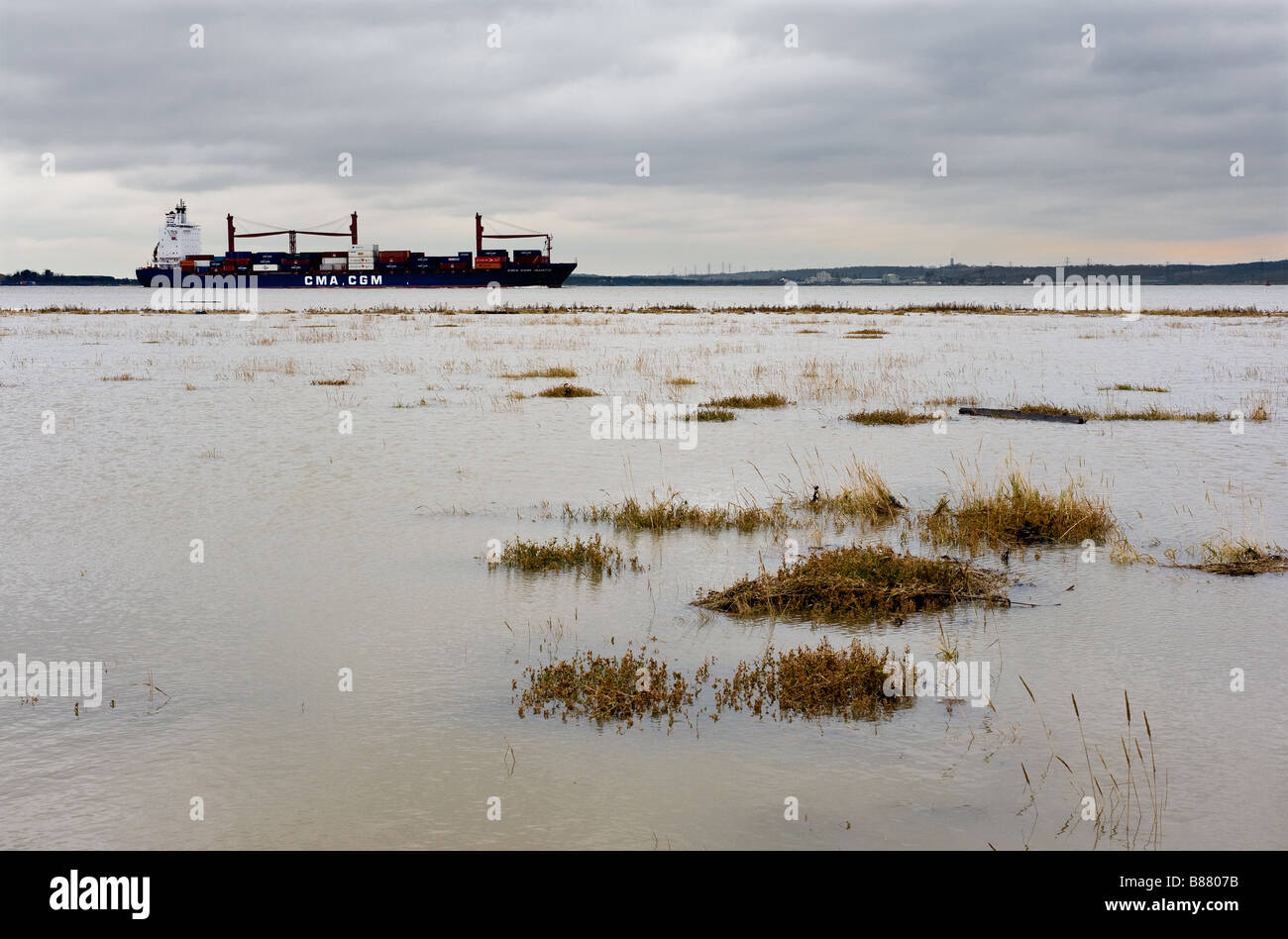 A container ship steaming upriver on the River Thames in Essex Stock ...