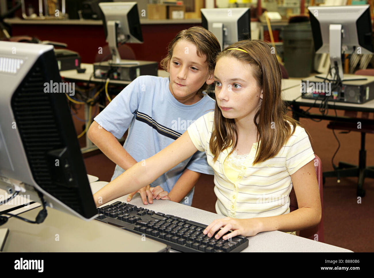 A girl and a boy student doing research together in the computer lab at ...