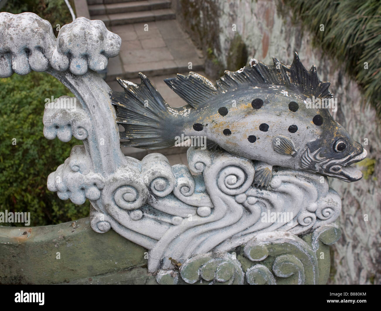 Fish carved from stone decorating the edge of the roof in a typical ...
