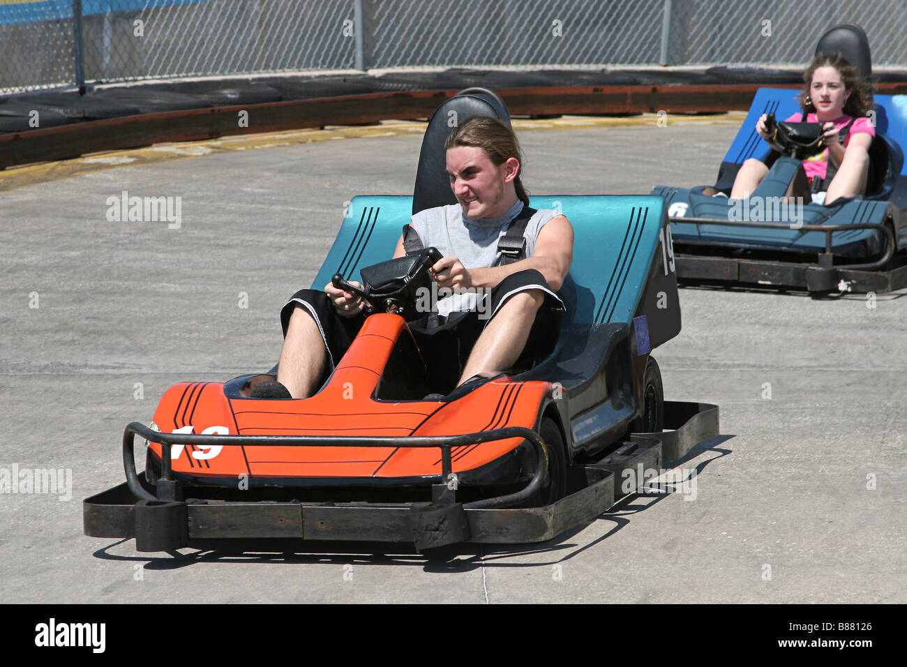 two teenagers racing go carts Stock Photo - Alamy