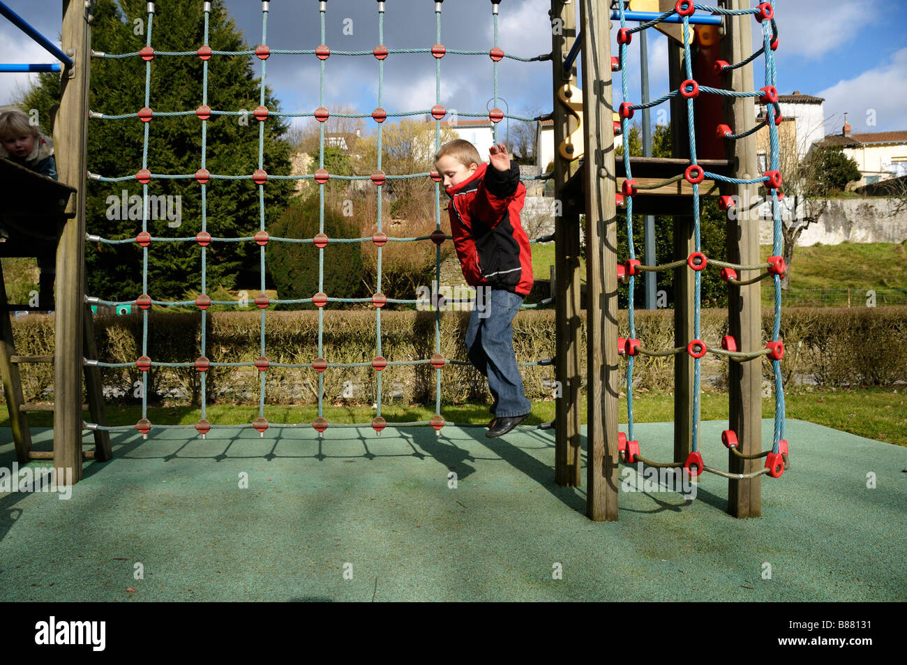Stock photo of a 9 year old boy jumping off a climbing frame in a ...