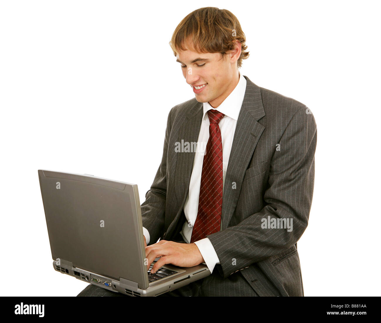 Handsome young businessman typing on his laptop Isolated on white Stock ...