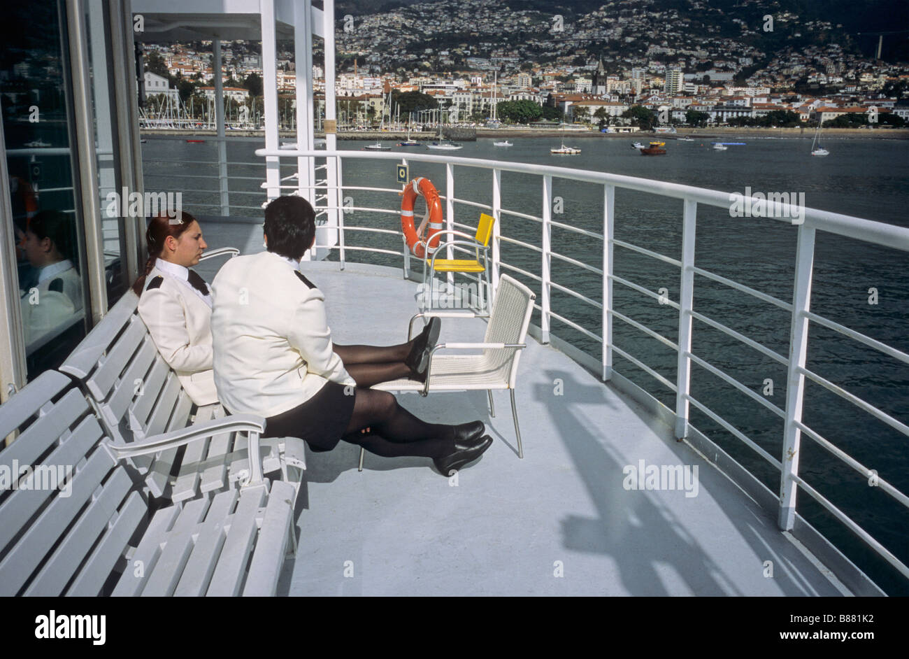 cruise ship staff members relaxing on the stern of a boat anchored in ...