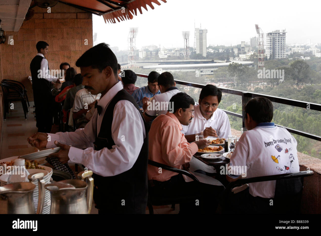 Young Indian computer engineers eat lunch at a restaurant with a view ...