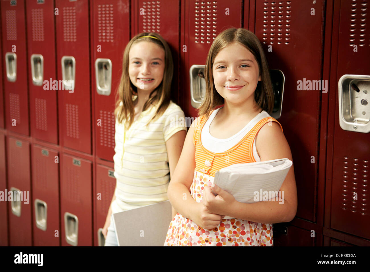 Two adolescent school girls in front of their lockers Stock Photo - Alamy