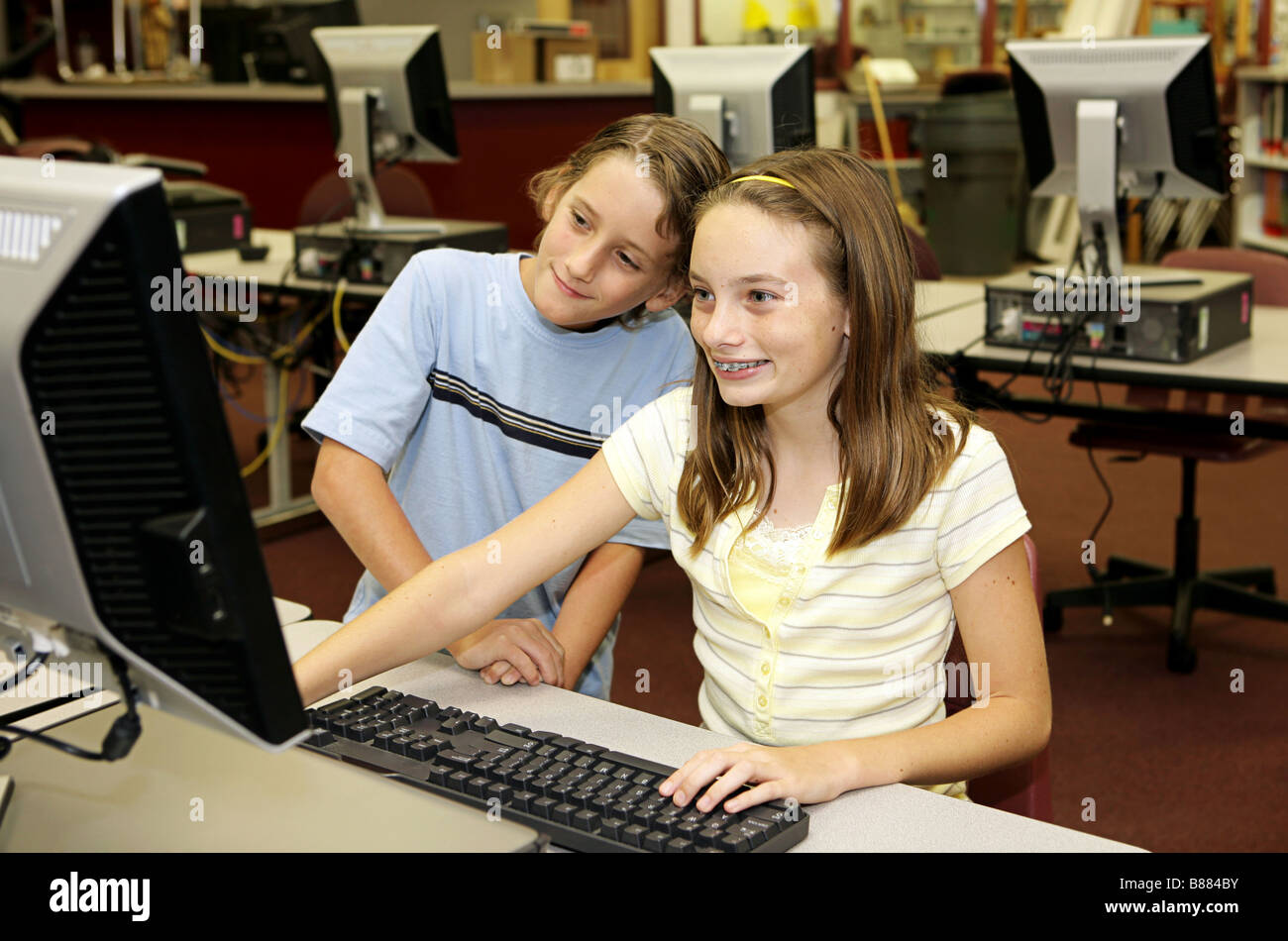 Two school children doing research together on the library computers ...