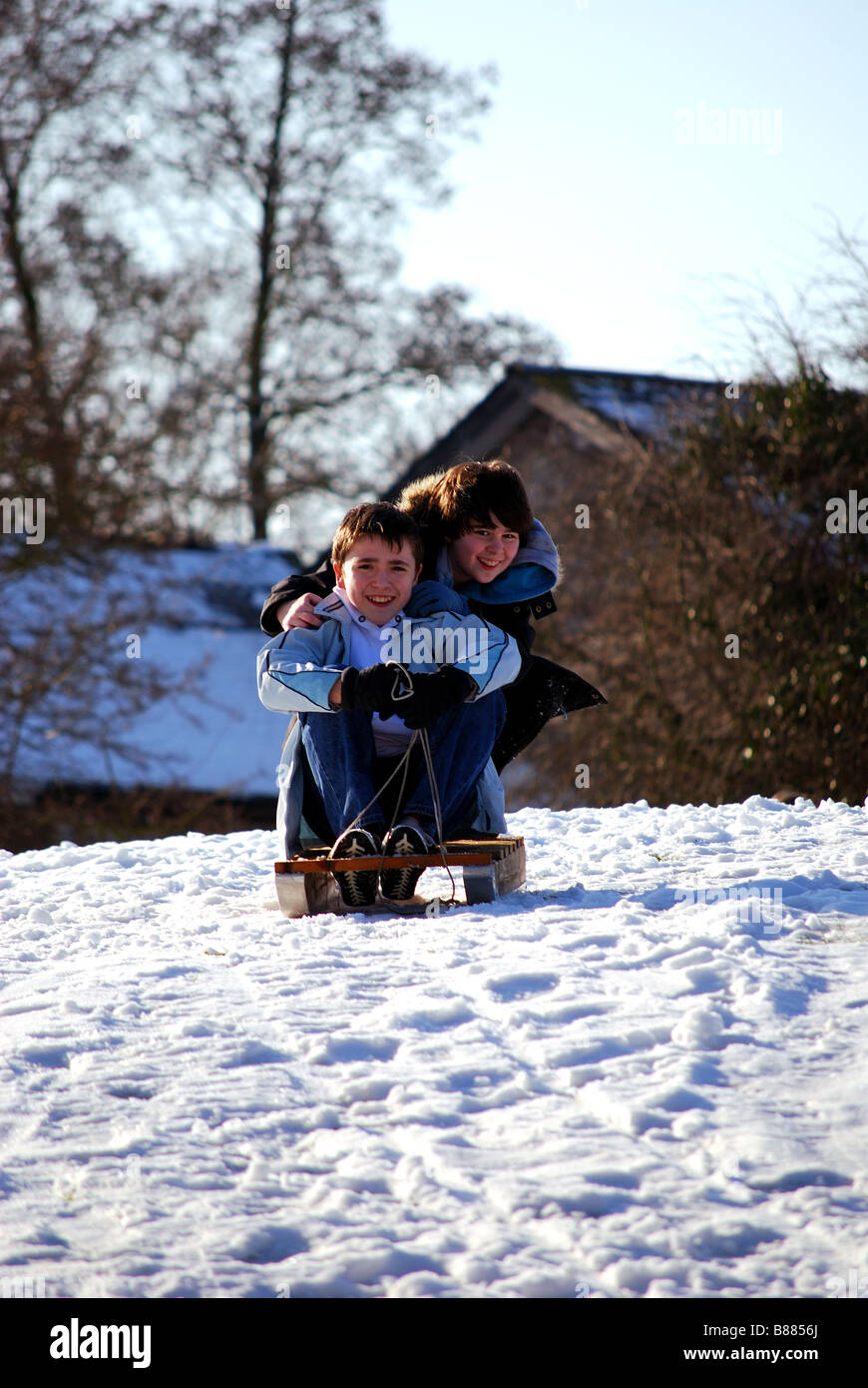 Two boys on a sledge Stock Photo - Alamy