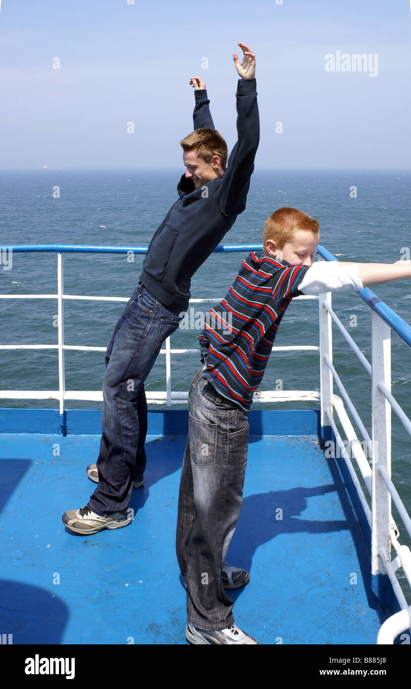 Boys leaning into wind Stock Photo - Alamy