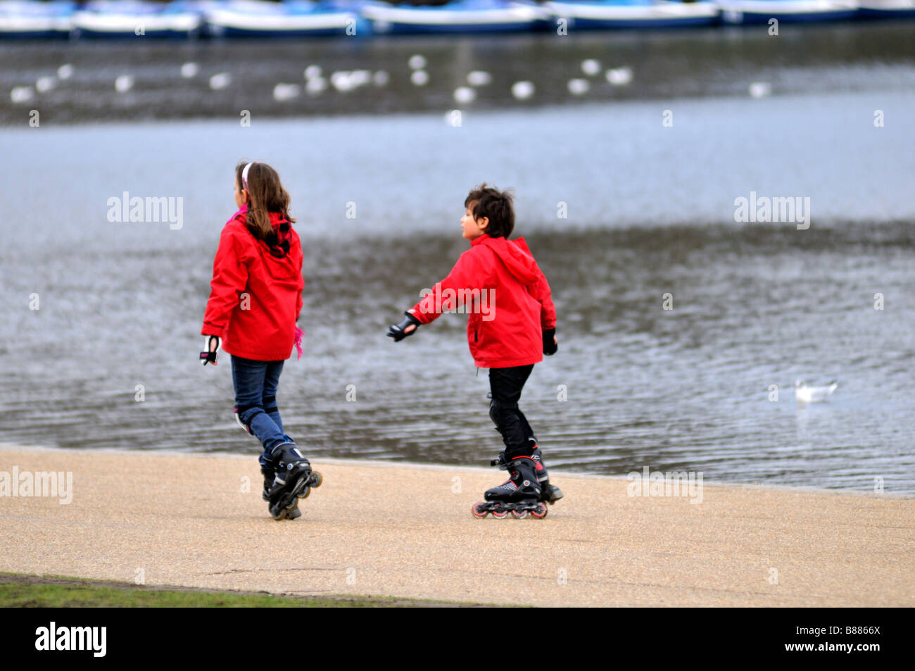 Children inline skating beside the serpentine lake in Hyde Park London ...