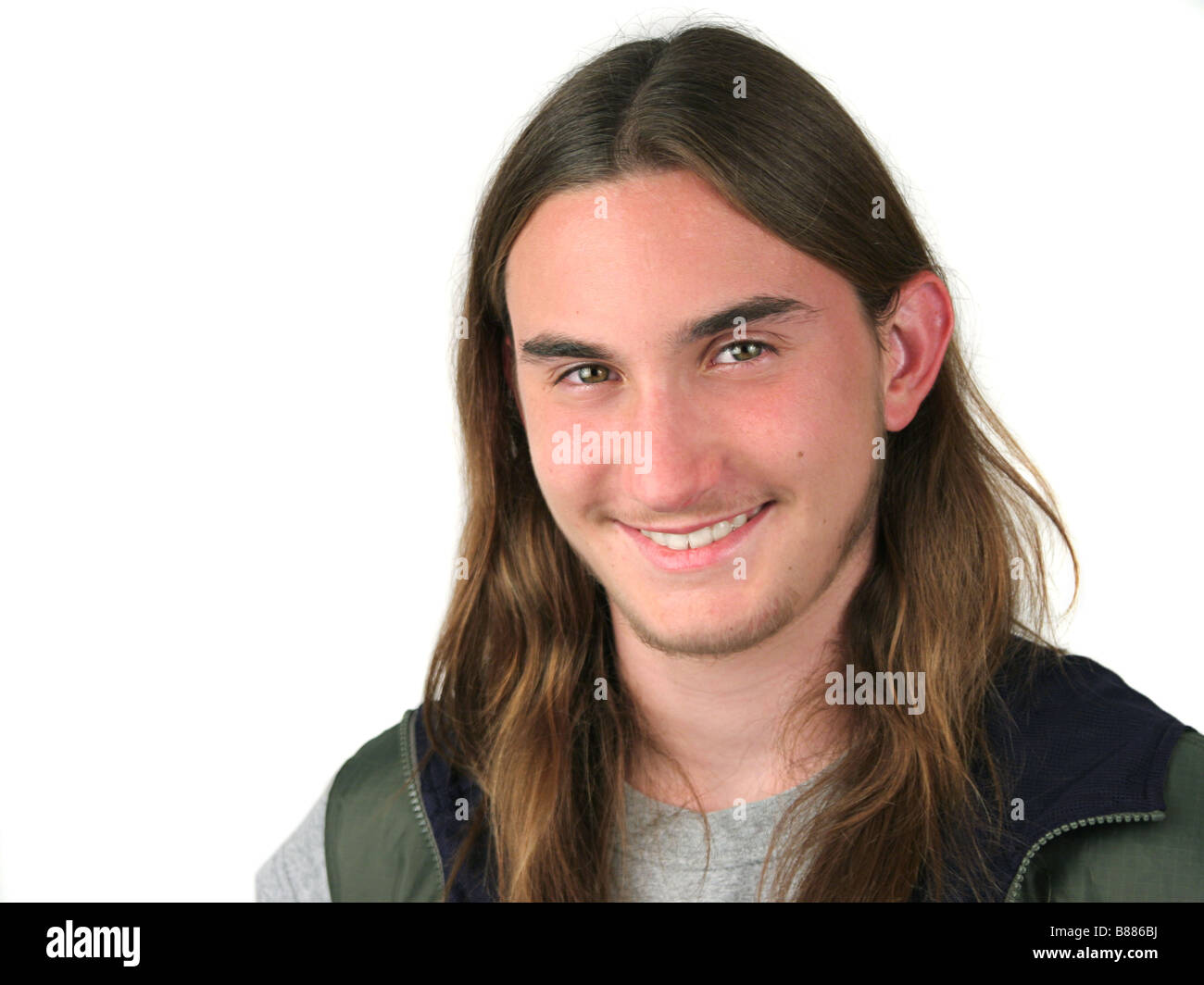 Friendly young man with long hair and a shy expression Stock Photo - Alamy