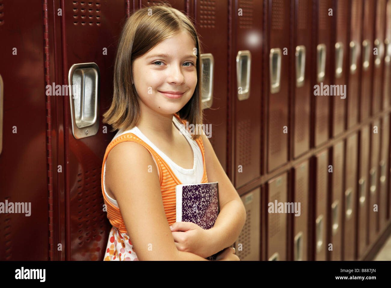 A pretty school girl leaning against her locker Stock Photo - Alamy