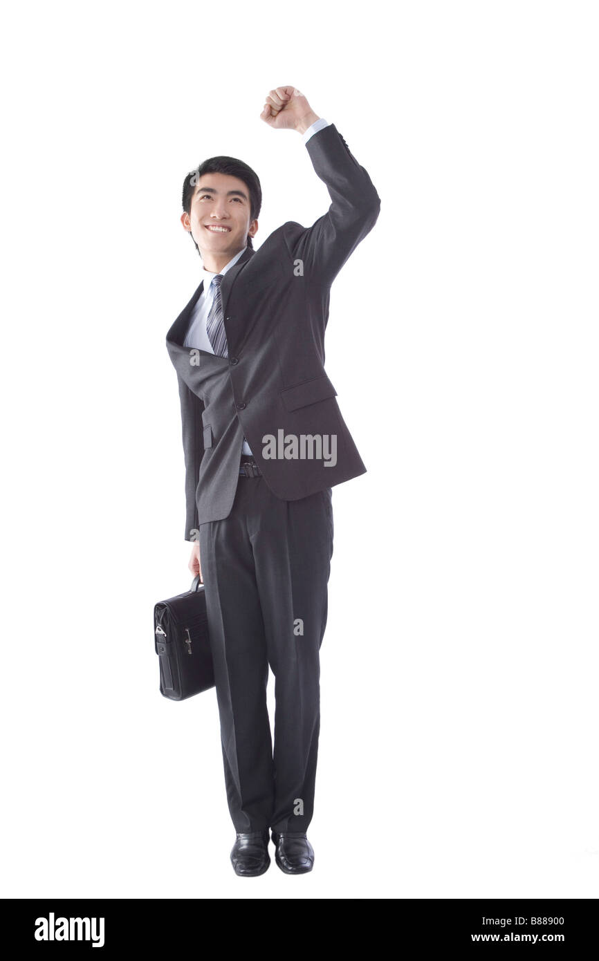 Businessman holding briefcase clenching fist Stock Photo - Alamy
