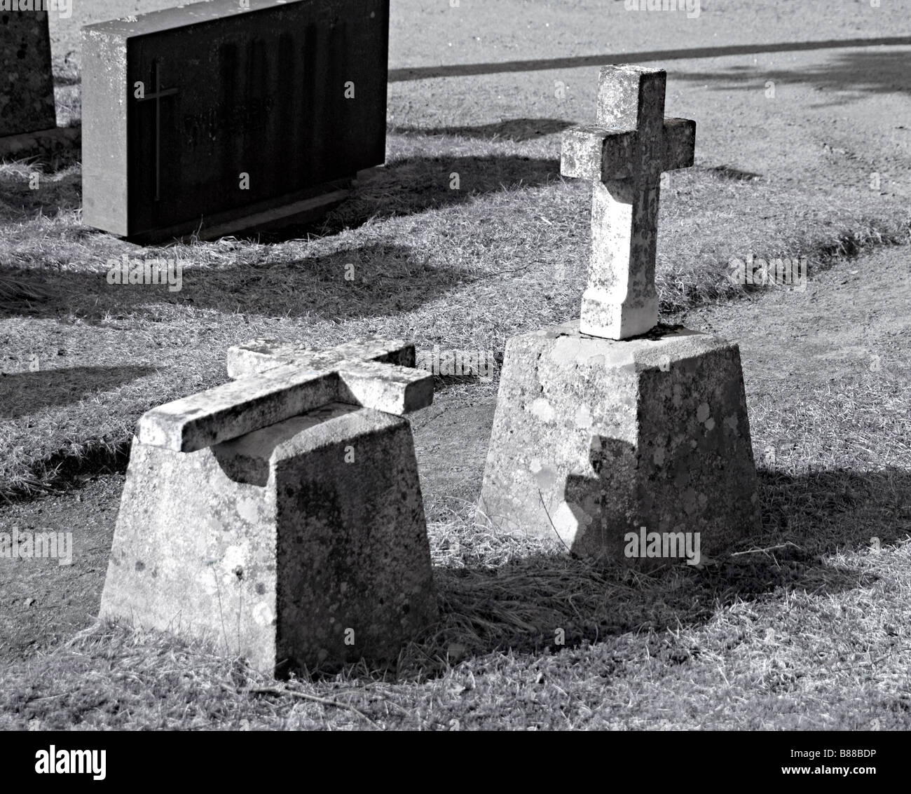 Fallen cross lying next to a standing cross on a graveyard Stock Photo ...