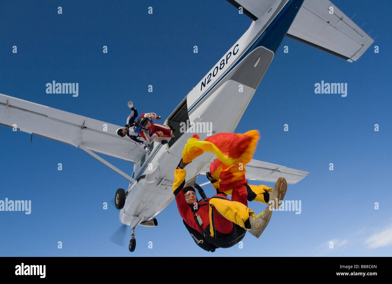 Skydivers are exiting a plane and holding an air tube. In this freefly ...