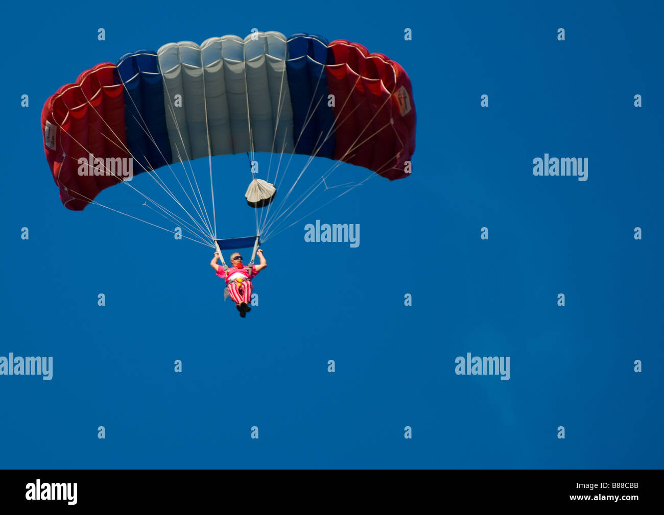 Parachute jumper coming down with his parachute Stock Photo - Alamy