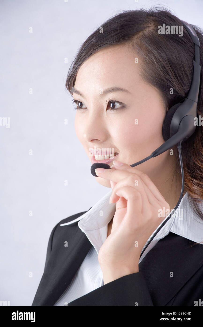 Young businesswoman with headset smiling side view Stock Photo - Alamy