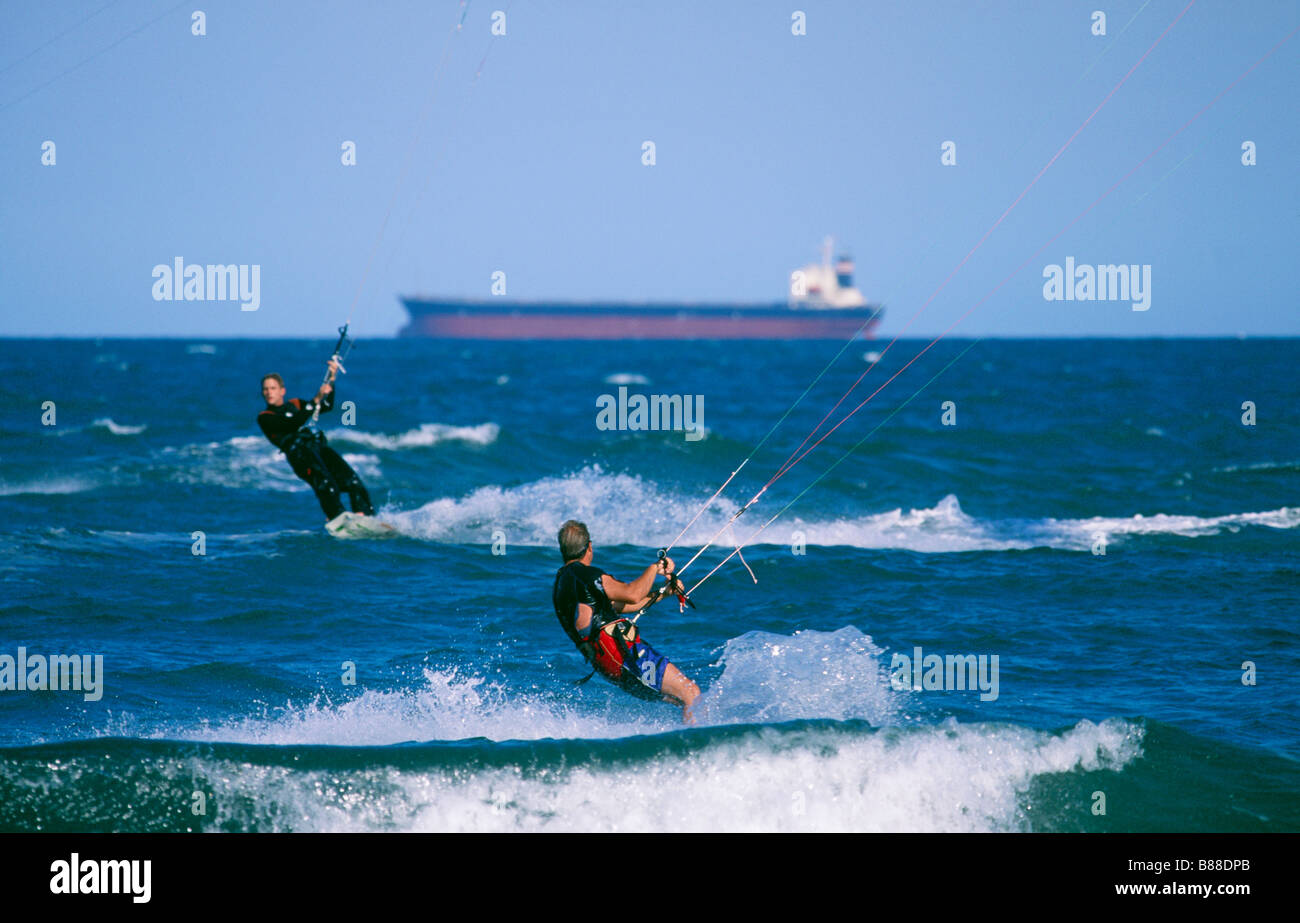 Newcastle Beach Two people in harnesses kitesurfing Holding strings of ...