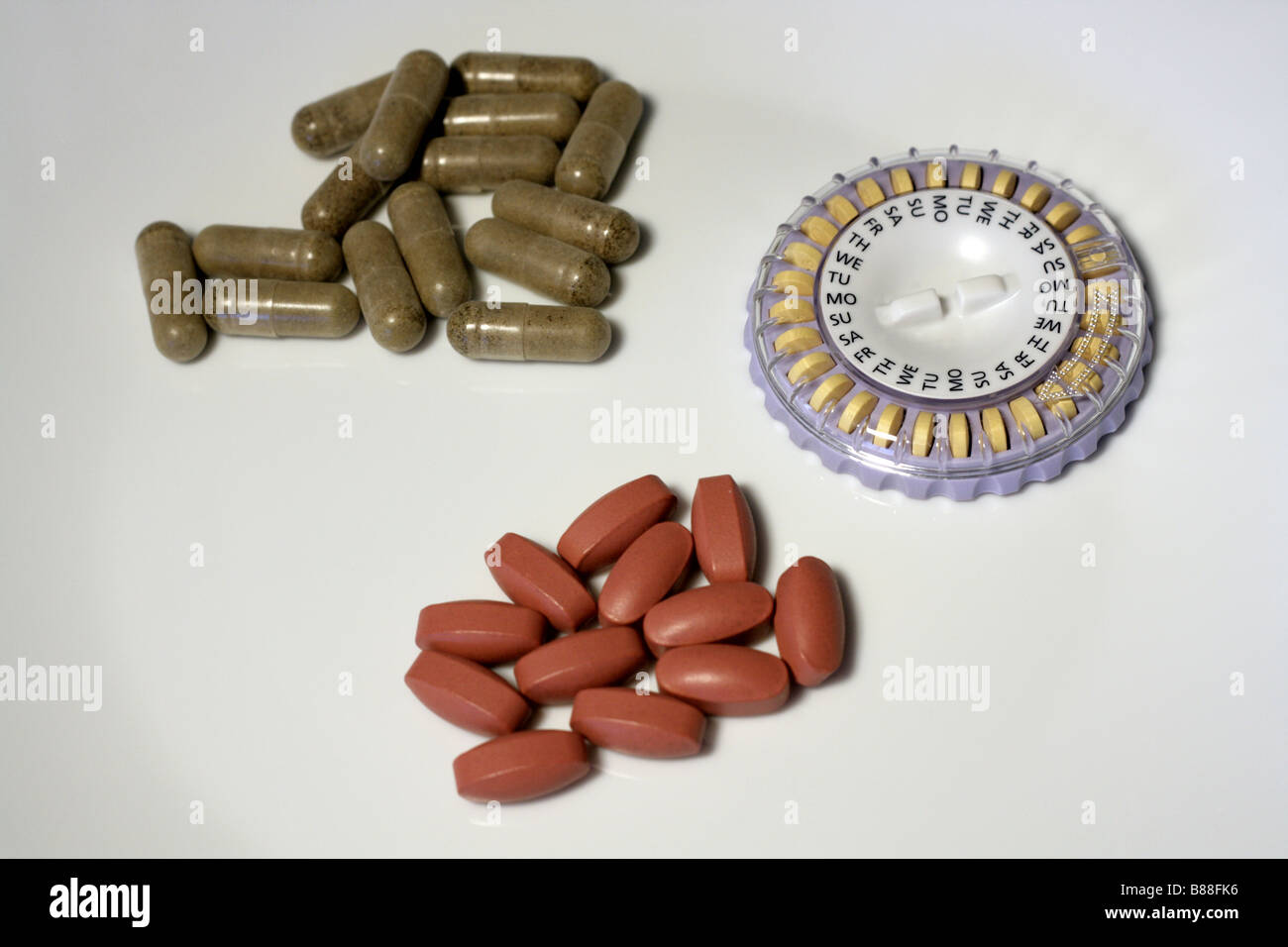 a selection of pills plus a tablet dispenser marked with days of the ...