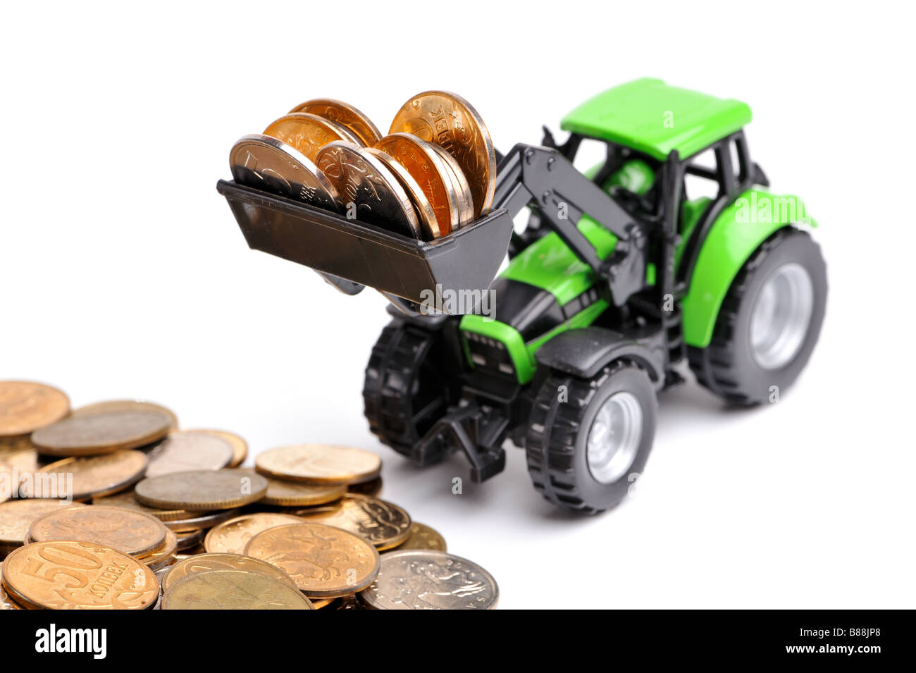 Green tractor raking up coins white background Stock Photo - Alamy