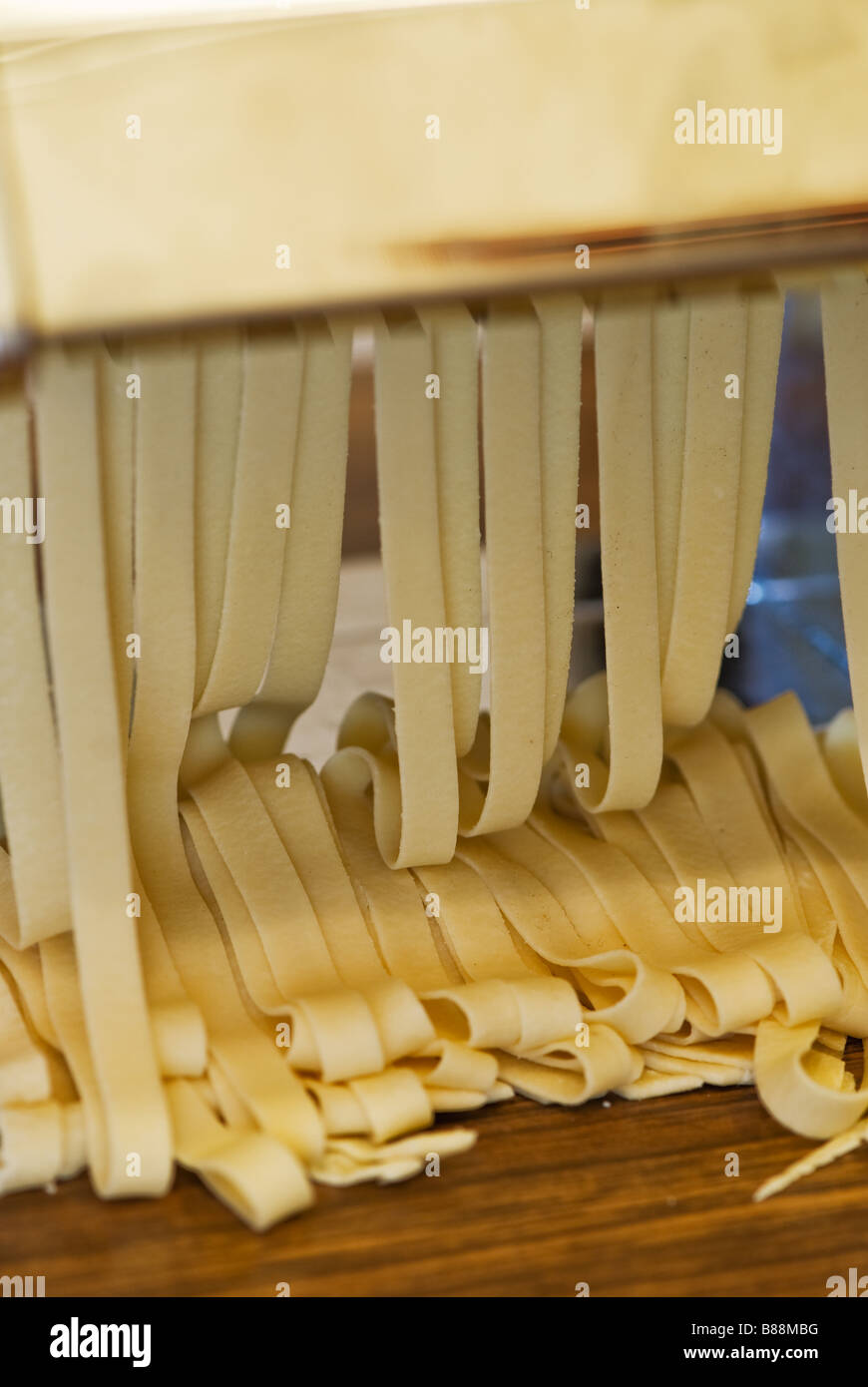 Freshly made pasta coming out of the pasta machine Stock Photo - Alamy